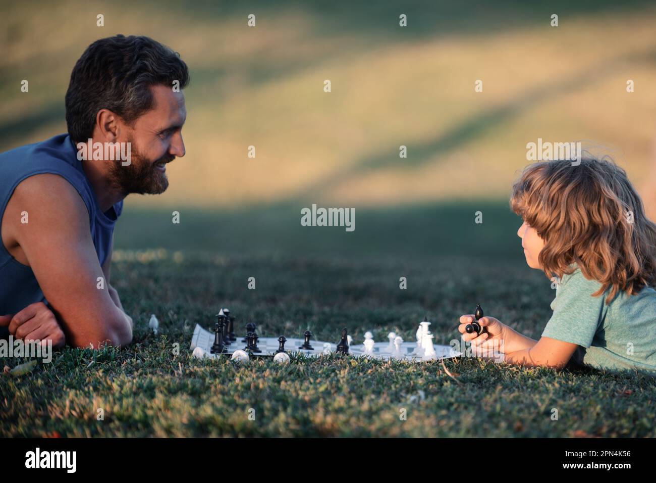 Father play chess with child son. Family outside game Stock Photo - Alamy