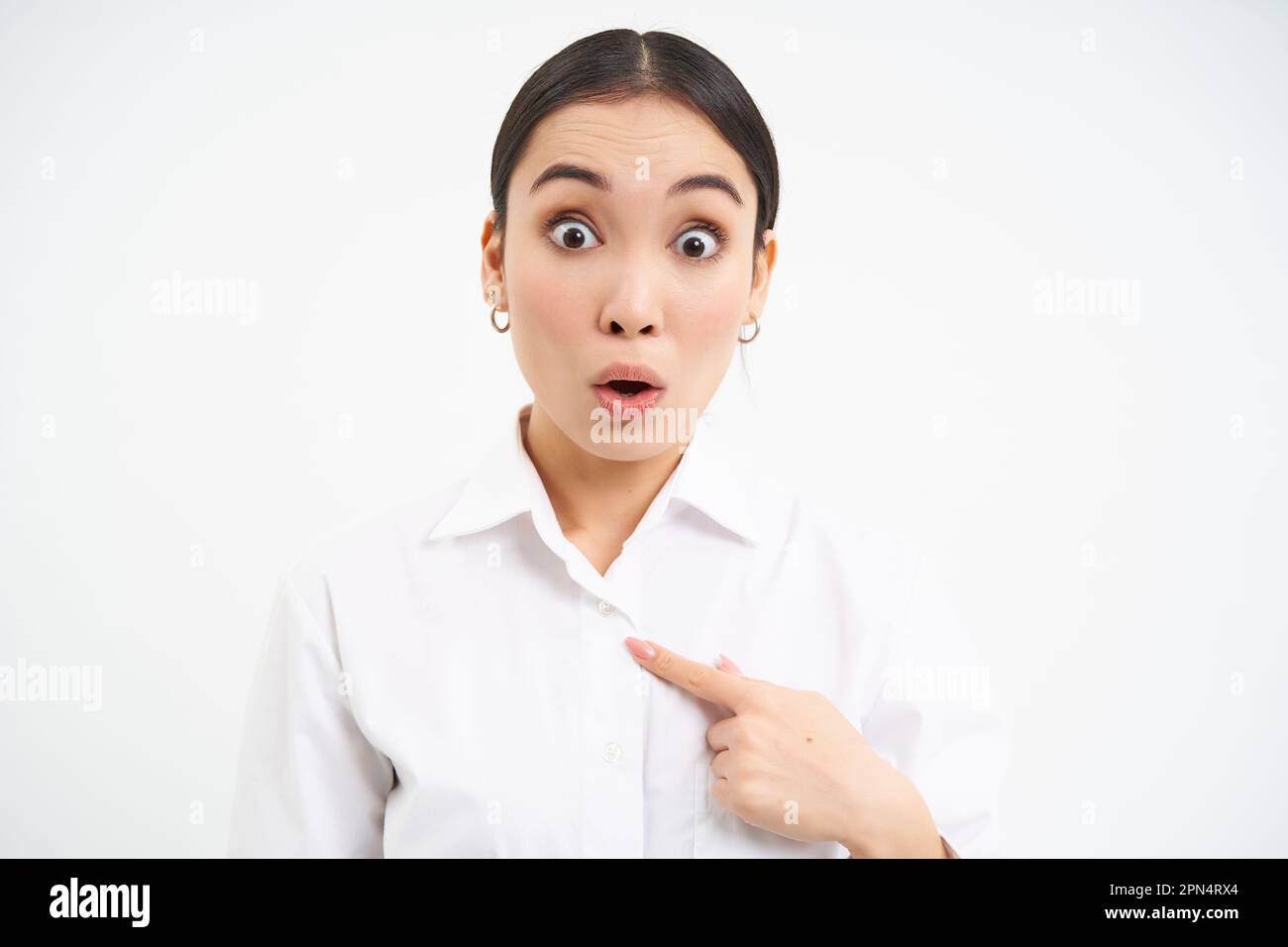 Portrait of asian businesswoman looks surprised, points at herself with ...