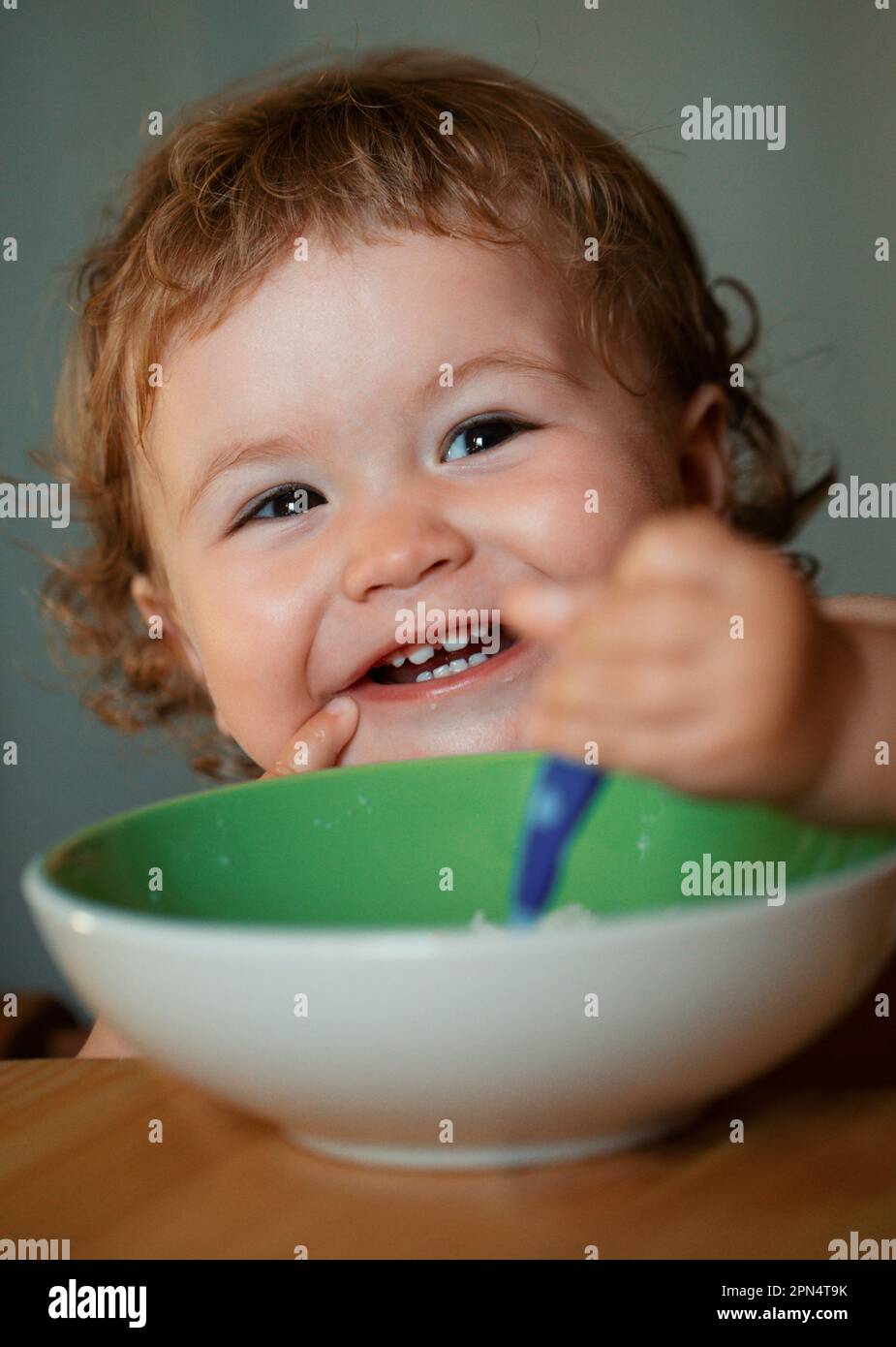 Baby putting food in mouth hi-res stock photography and images - Alamy