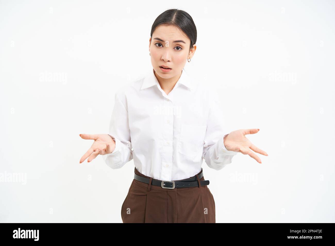 Image of confused asian saleswoman, spreads hands sideways with ...