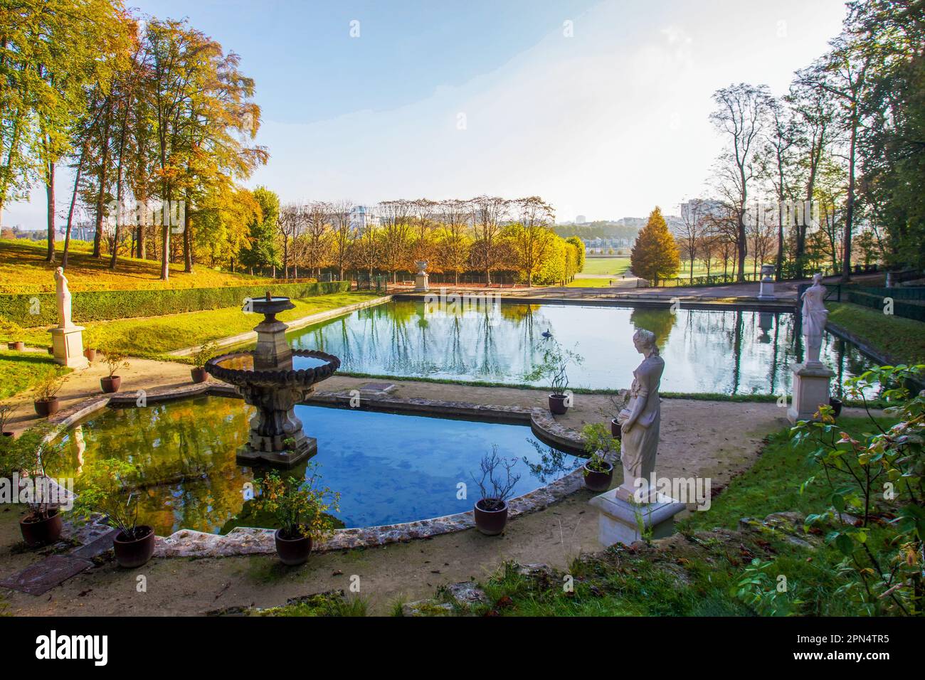 Idyllic landscape with pond statues, potted plants in Saint-Cloud park ...