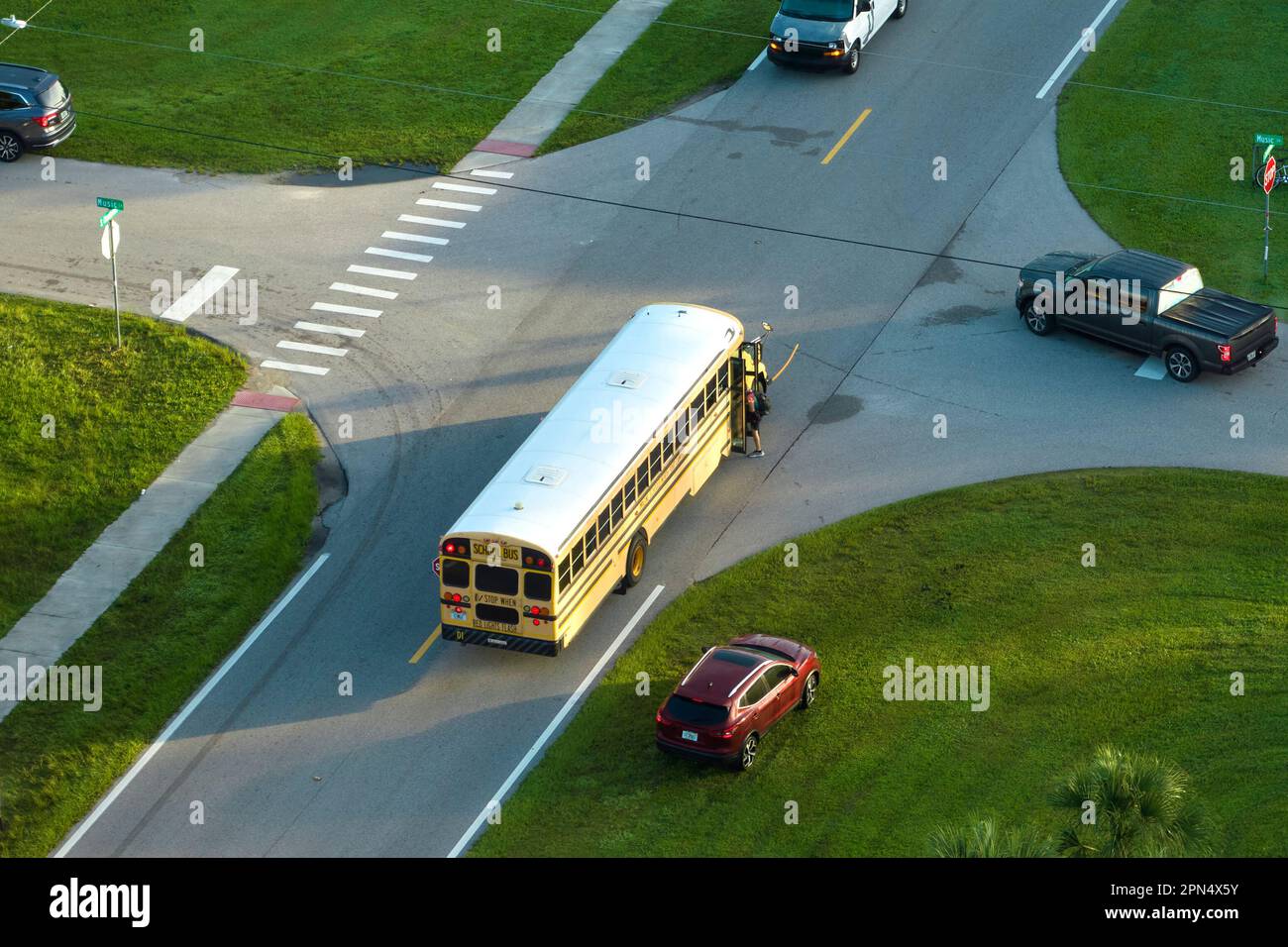 Aerial view of american yellow school bus picking up children at ...