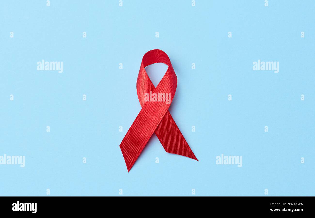 A silk red ribbon in the form of a bow on a blue background, a symbol ...