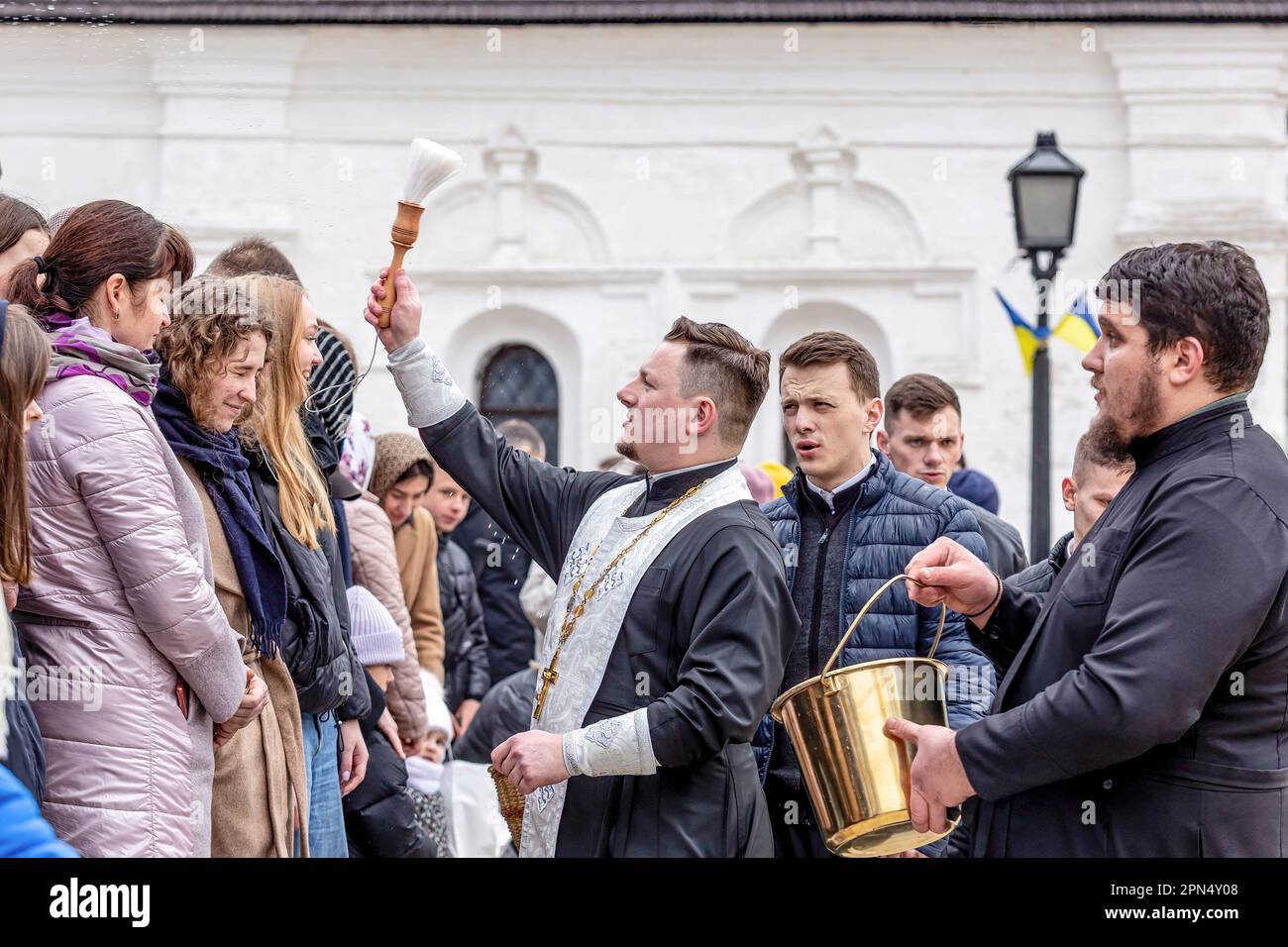 A priest blesses Ukrainian believers with Holy Water as they attend the ...