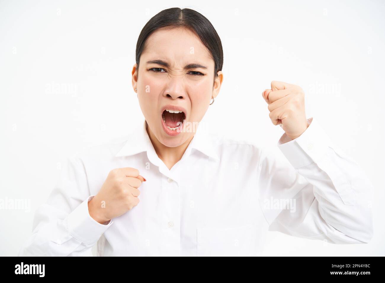 Angry asian woman yells and shakes fists, shouts at employees, stands ...