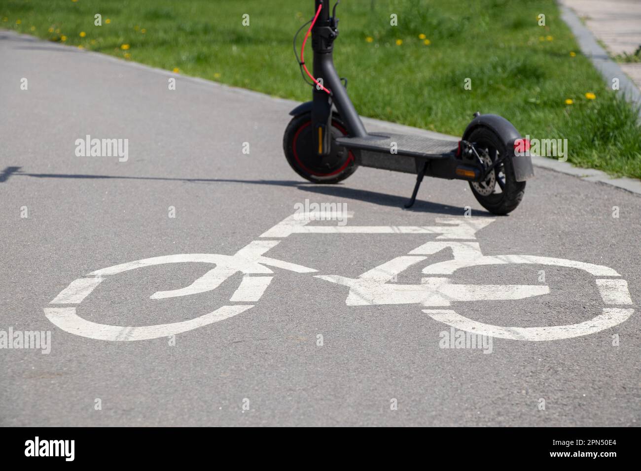An electric scooter stands on a bike path with bicycle markings on the ...