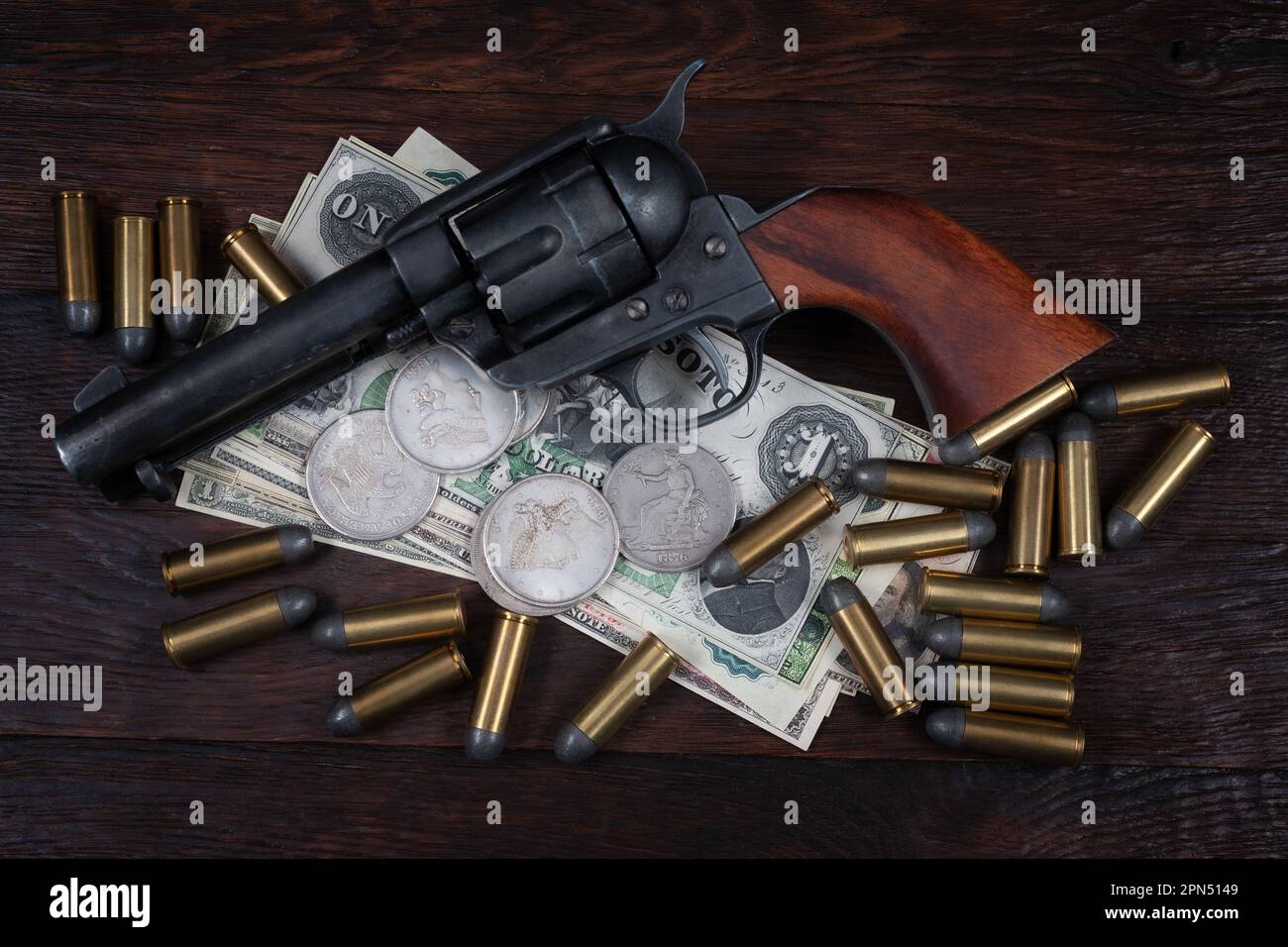 Old west Colt Peacemaker and US banknotes and silver certificates with ...