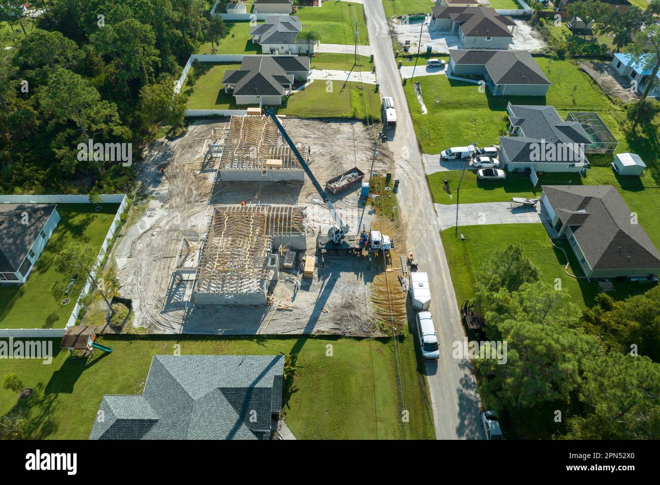 Lifting crane truck and builders working on roof construction of ...