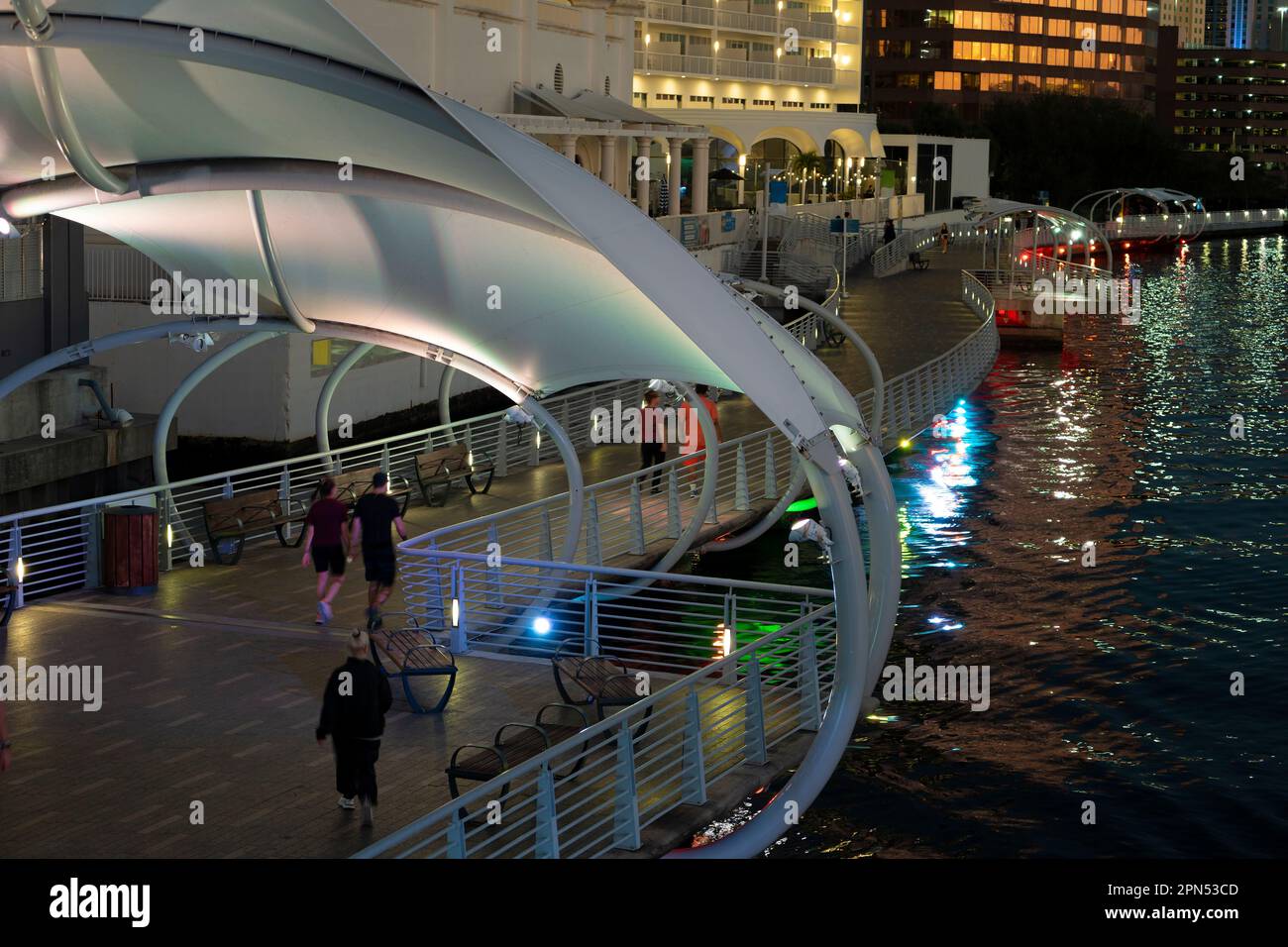 People enjoying time walking on pedestrian riverwalk trail alongside ...