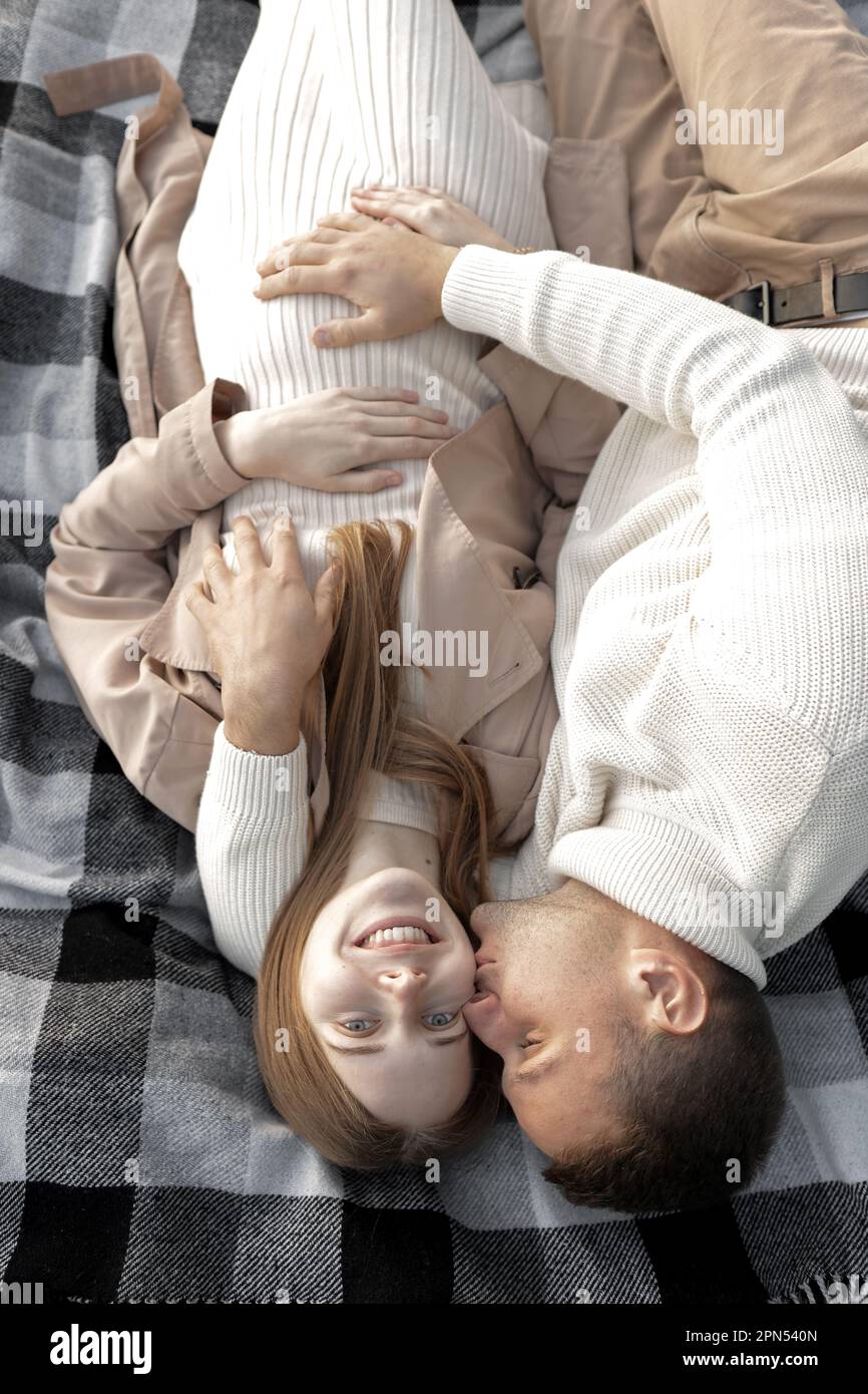 Happy family day. Top view of man and pregnant wife embrace and lie on ...