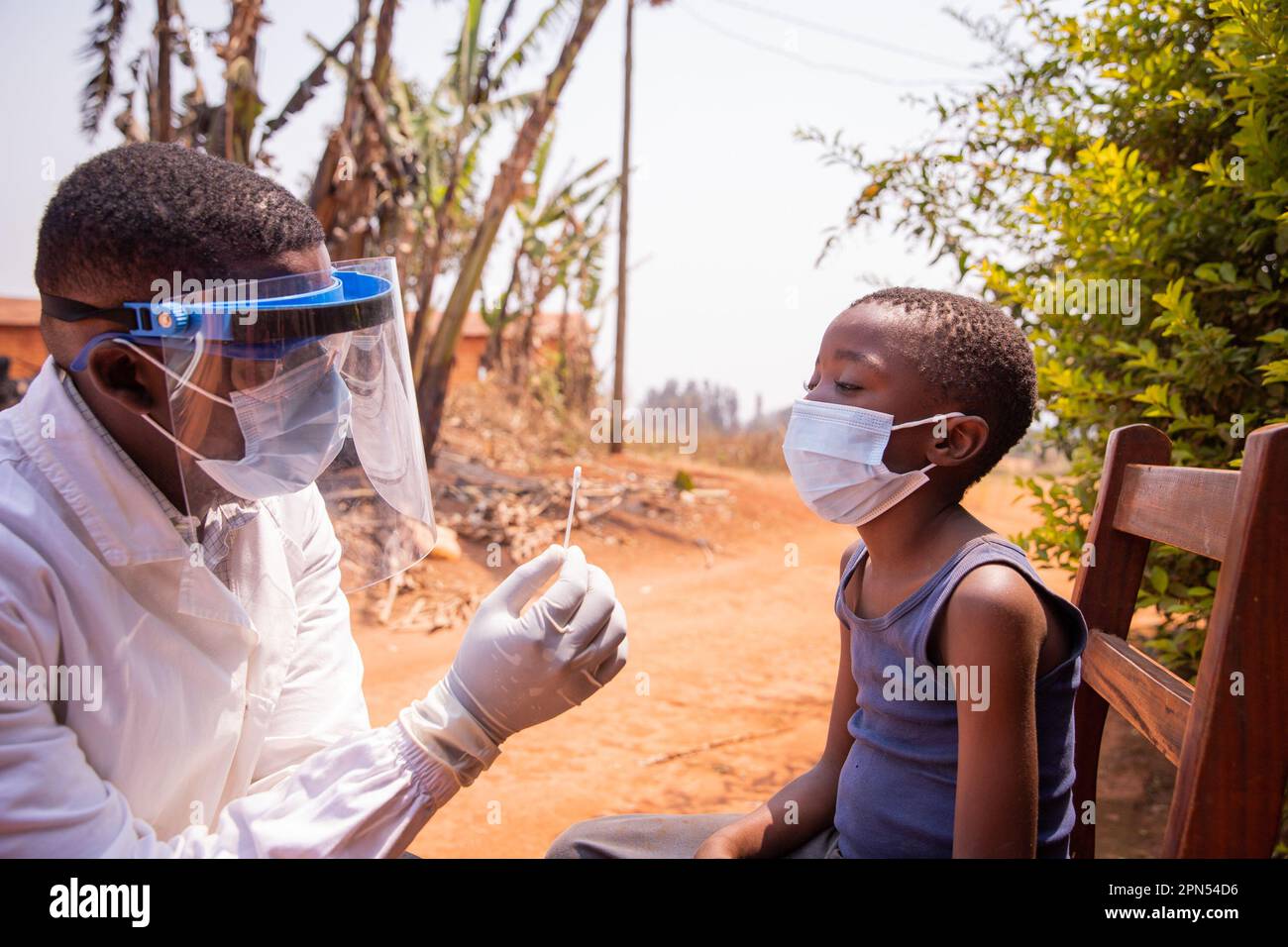 A doctor holding a swab to perform a molecular test on a child in ...