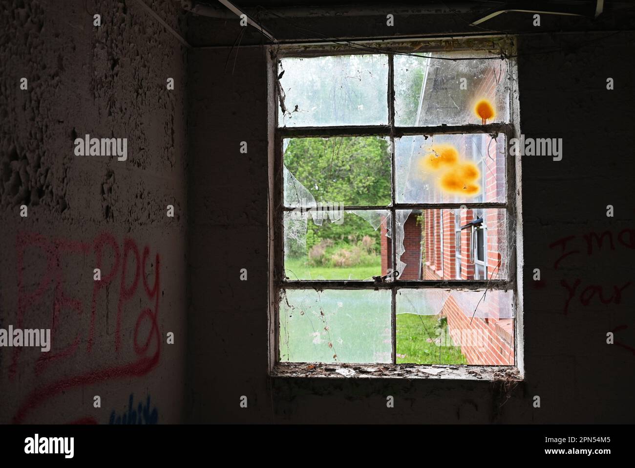 A broken window in the hallway of a school that has been abandoned ...