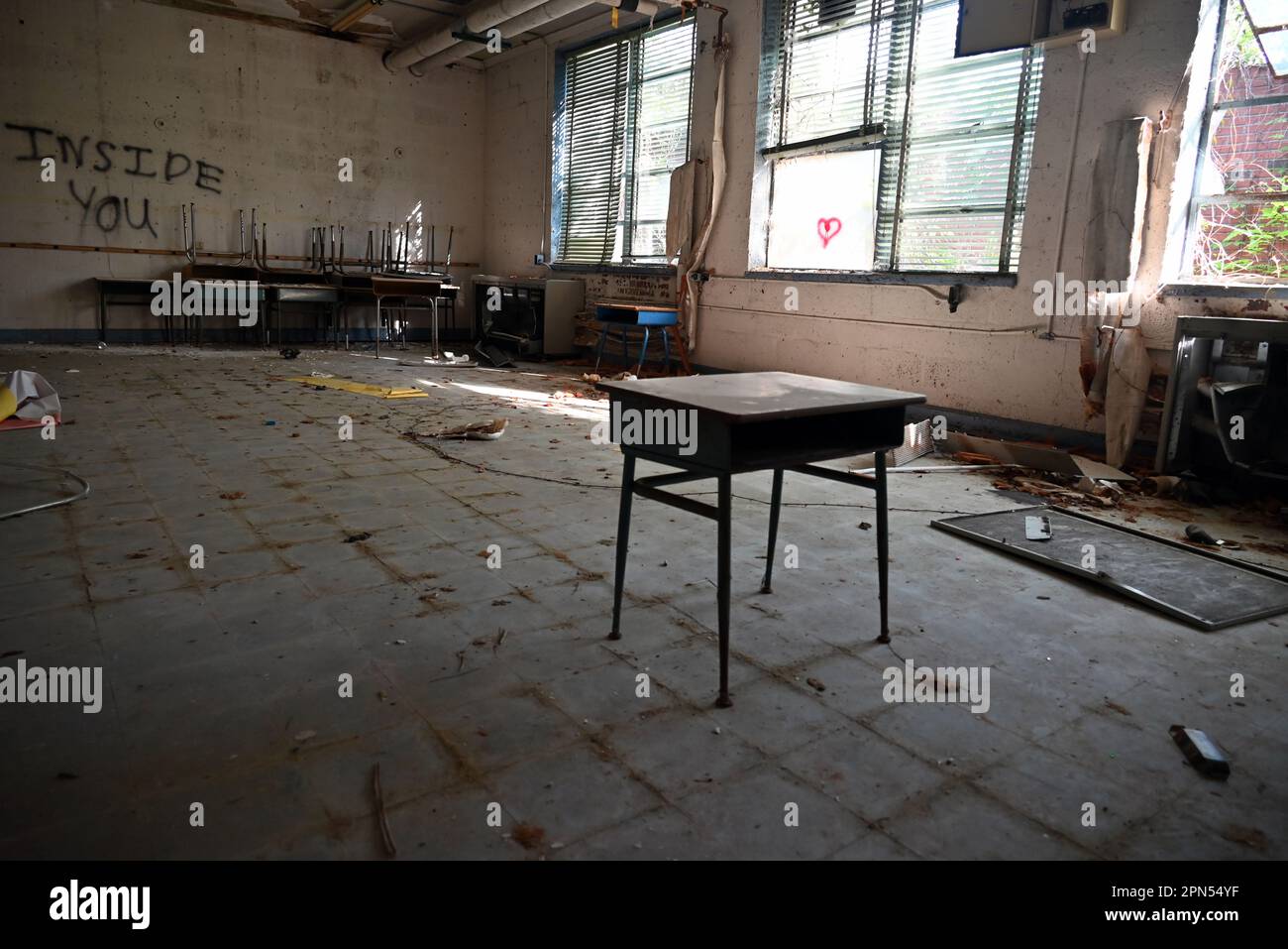 A student desk sits in a debris filled classroom at a school vandalized ...