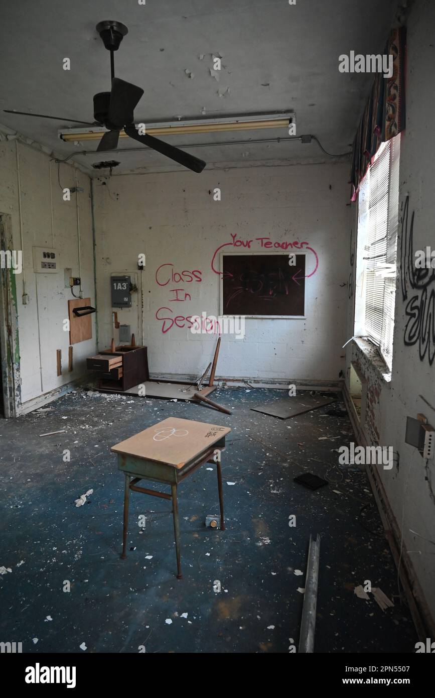 A student desk sits in a debris filled classroom at a school vandalized ...