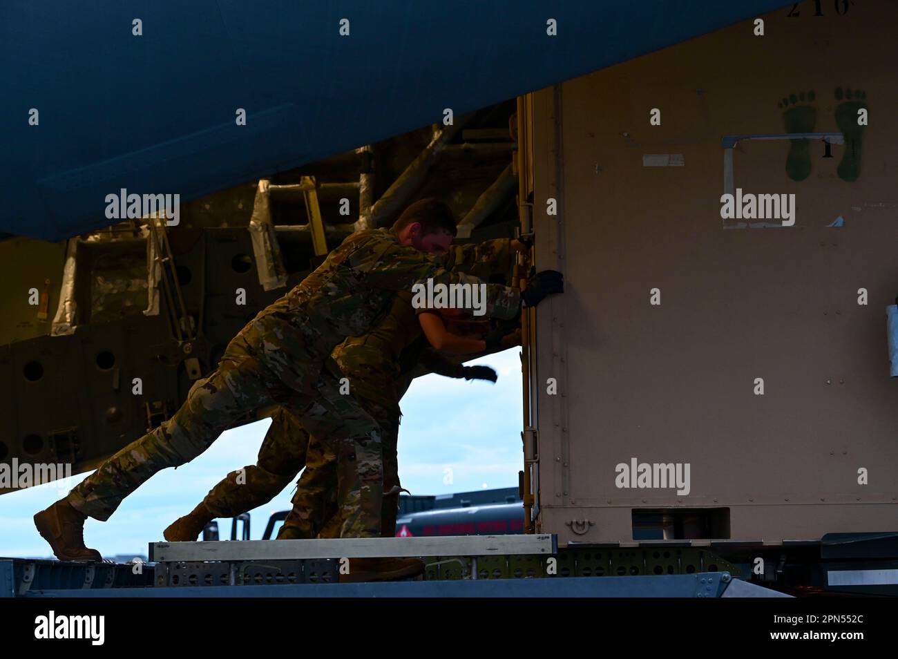 Aircrew assigned to the 156th Airlift Squadron unload equipment during ...