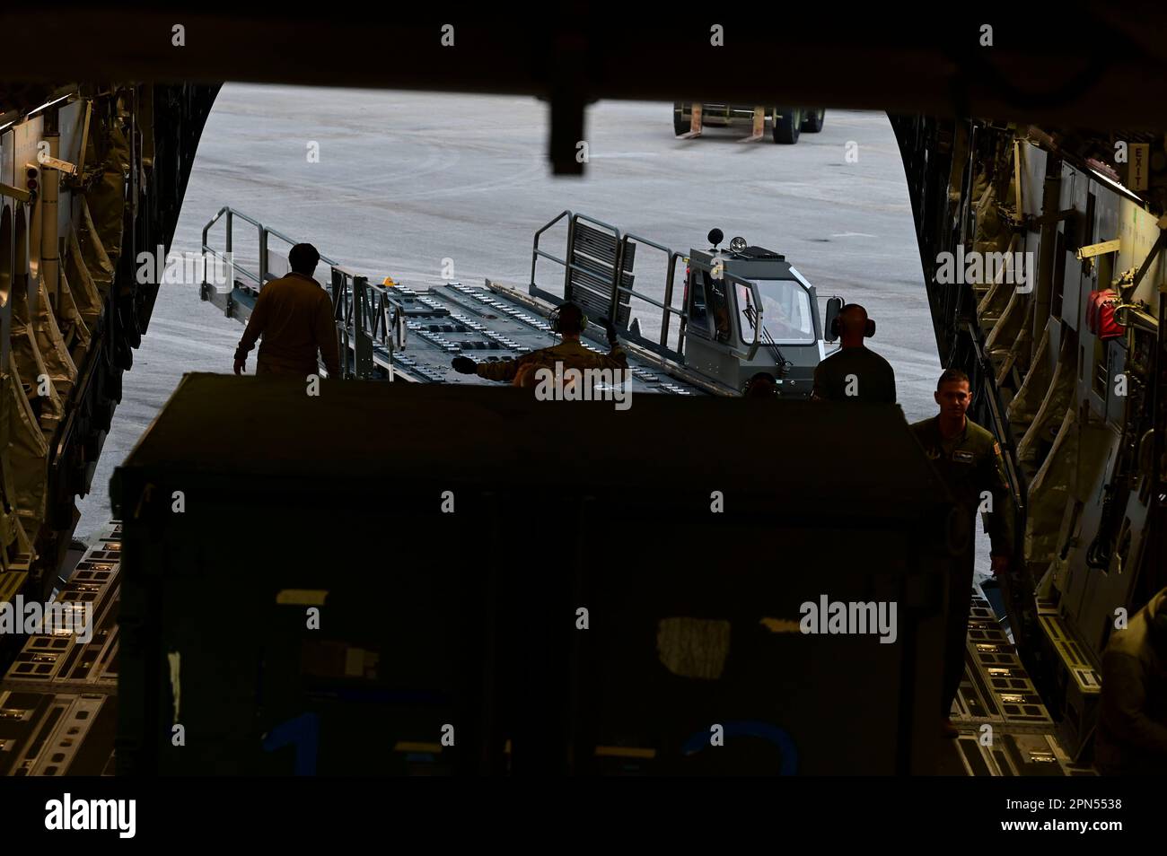 Aircrew assigned to the 156th Airlift Squadron unload equipment during ...