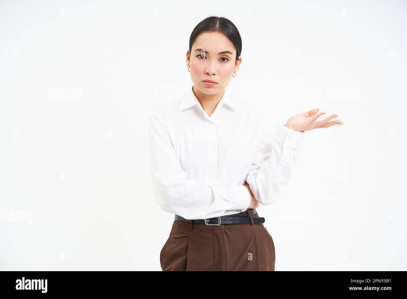 Professional businesswoman, looks puzzled at camera, extends one hand ...