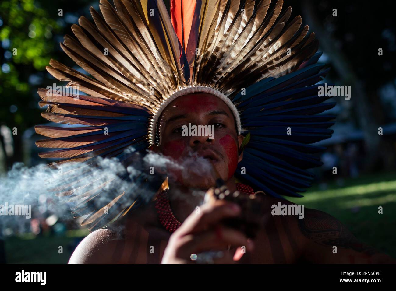Aratu Tupa, 25, a Pataxo Indigenous man smokes a traditional pipe ...