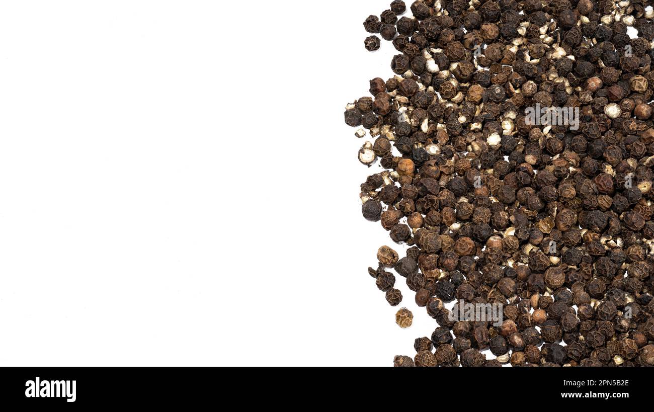 Pile of black peppercorns, a dried fermented seeds of Piper nigrum on a ...