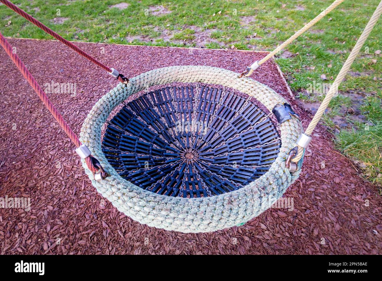 Close up of birds nest children's play swing hanging from rope in ...