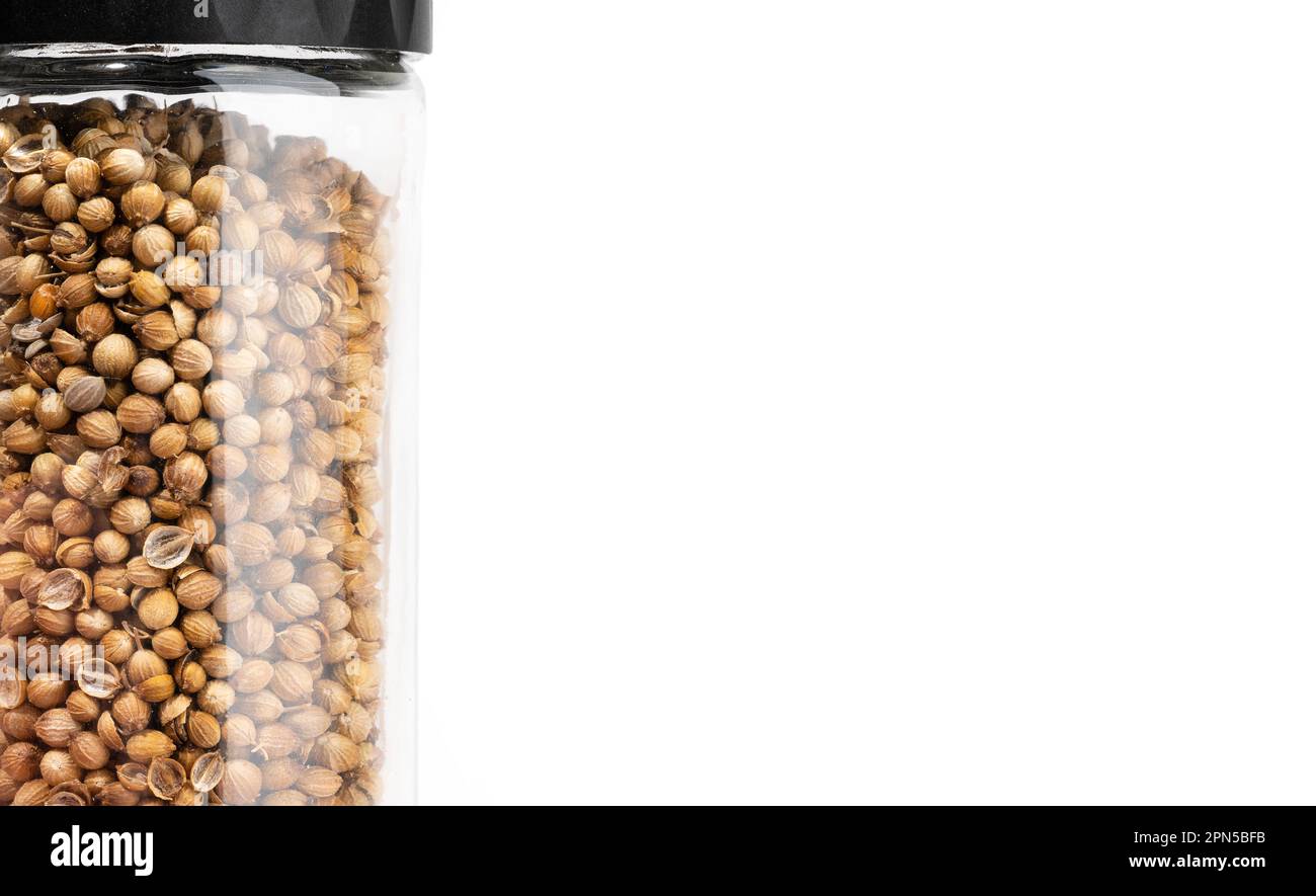 Organic Dried coriander seeds Coriandrum sativum in jar for seasonings and spices on a white ...