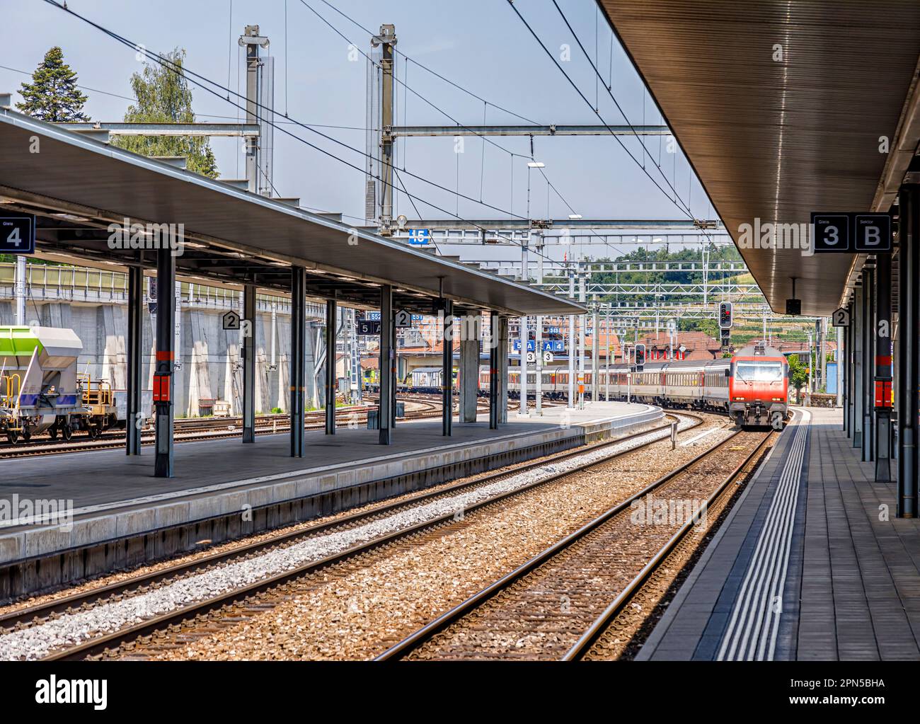 A red Swiss Rail train approaches the railway station at Spiez on Lake ...