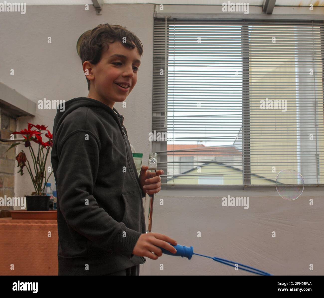 boy playing with bubbles near the window at his home Stock Photo - Alamy