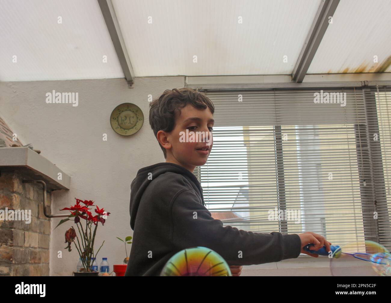 young boy having fun with bubbles near a window Stock Photo - Alamy