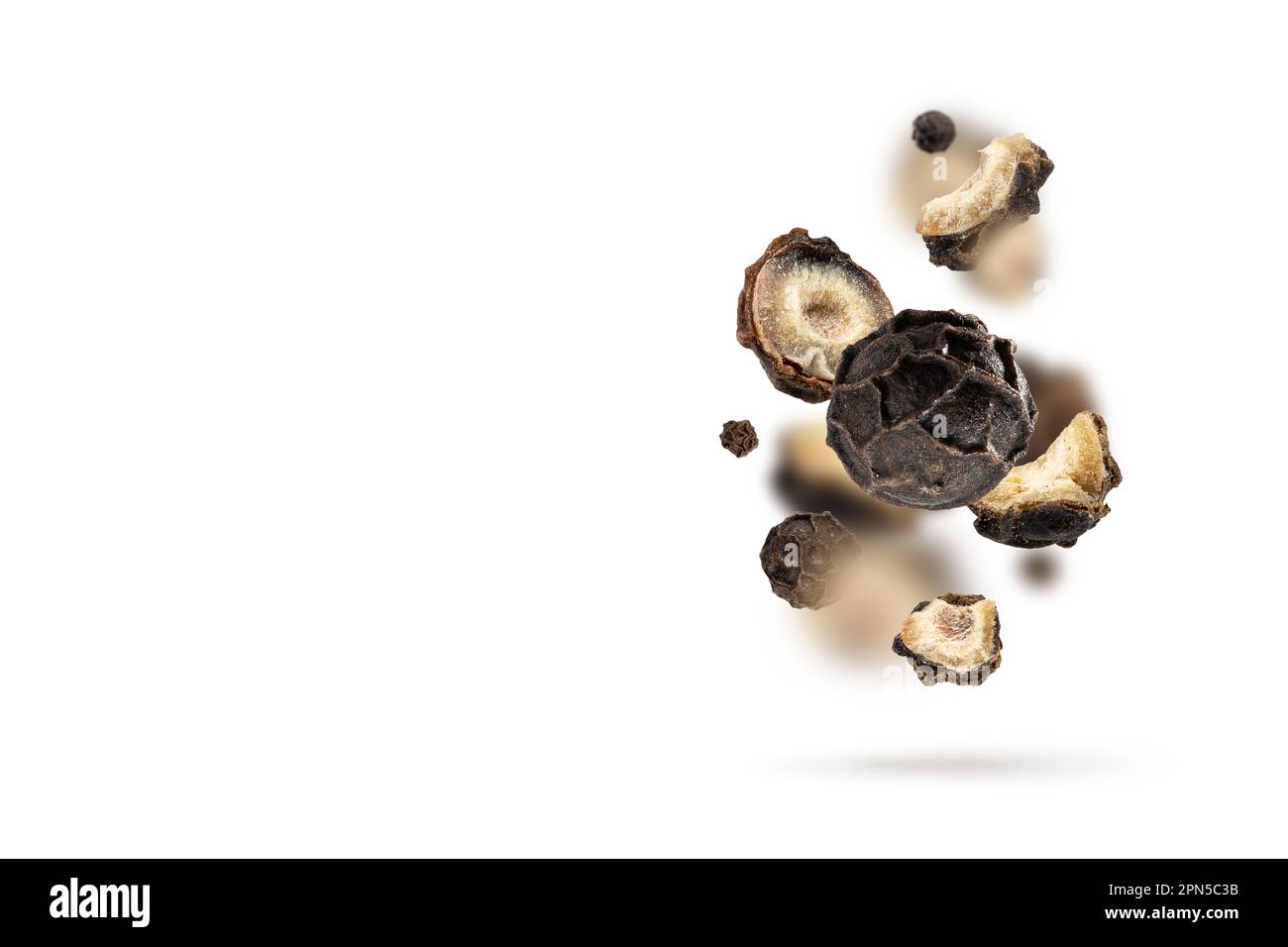 Close-up organic peppercorn, whole and sliced, flying on background ...
