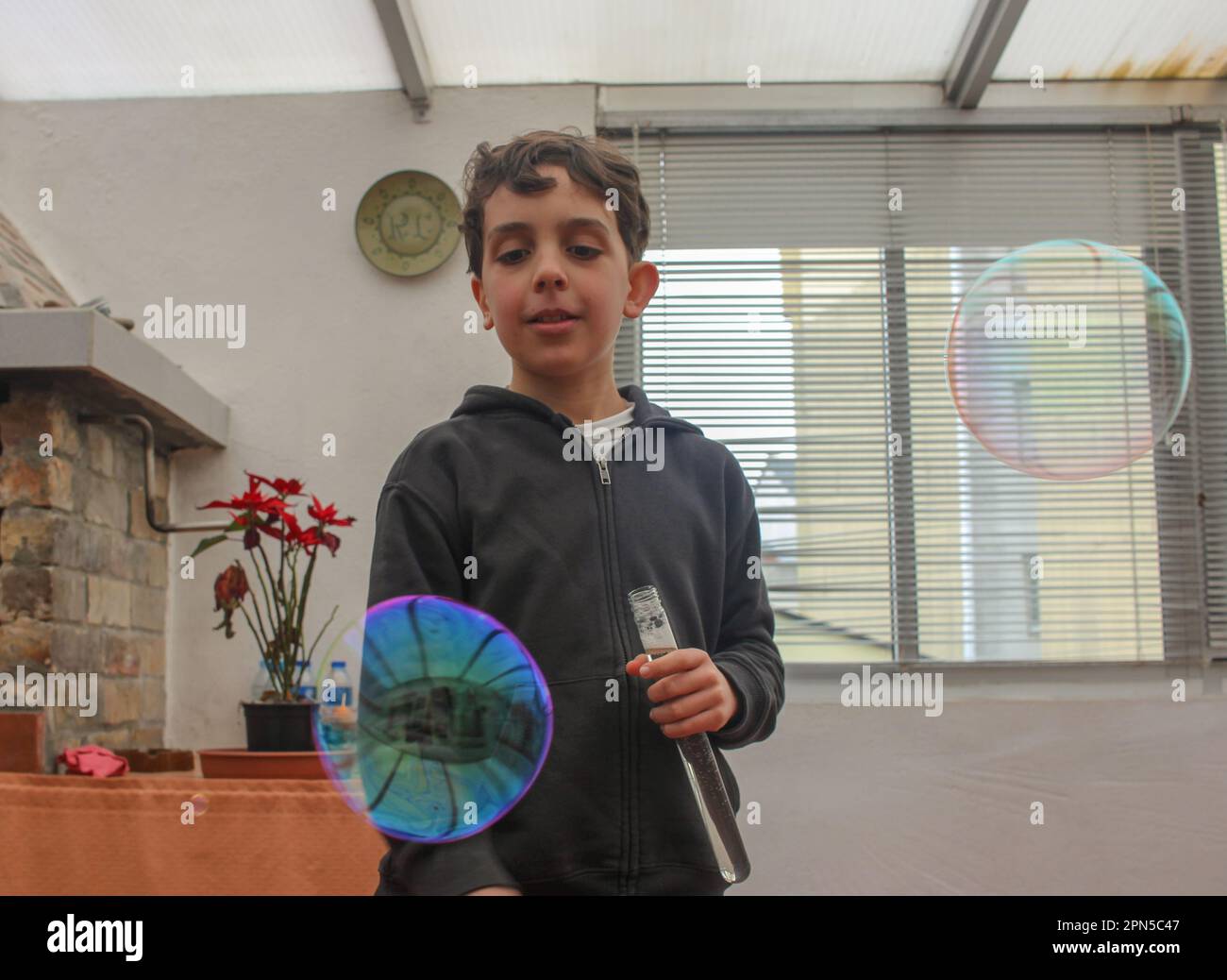 boy fascinated by how bubbles move inside his home Stock Photo - Alamy