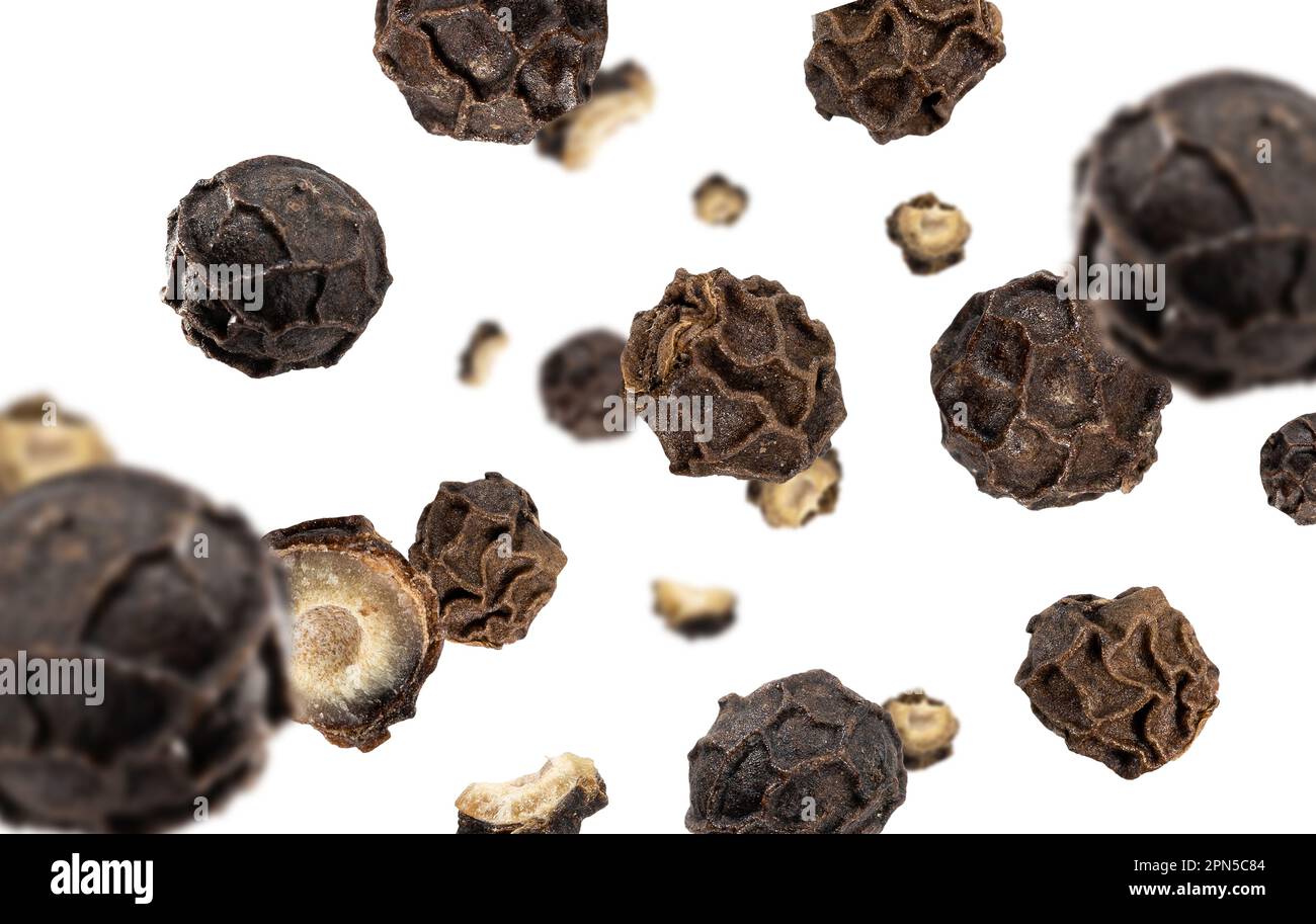 Close-up organic peppercorn, whole and sliced, flying on white ...