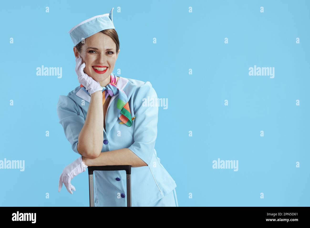 happy elegant female air hostess against blue background in blue ...