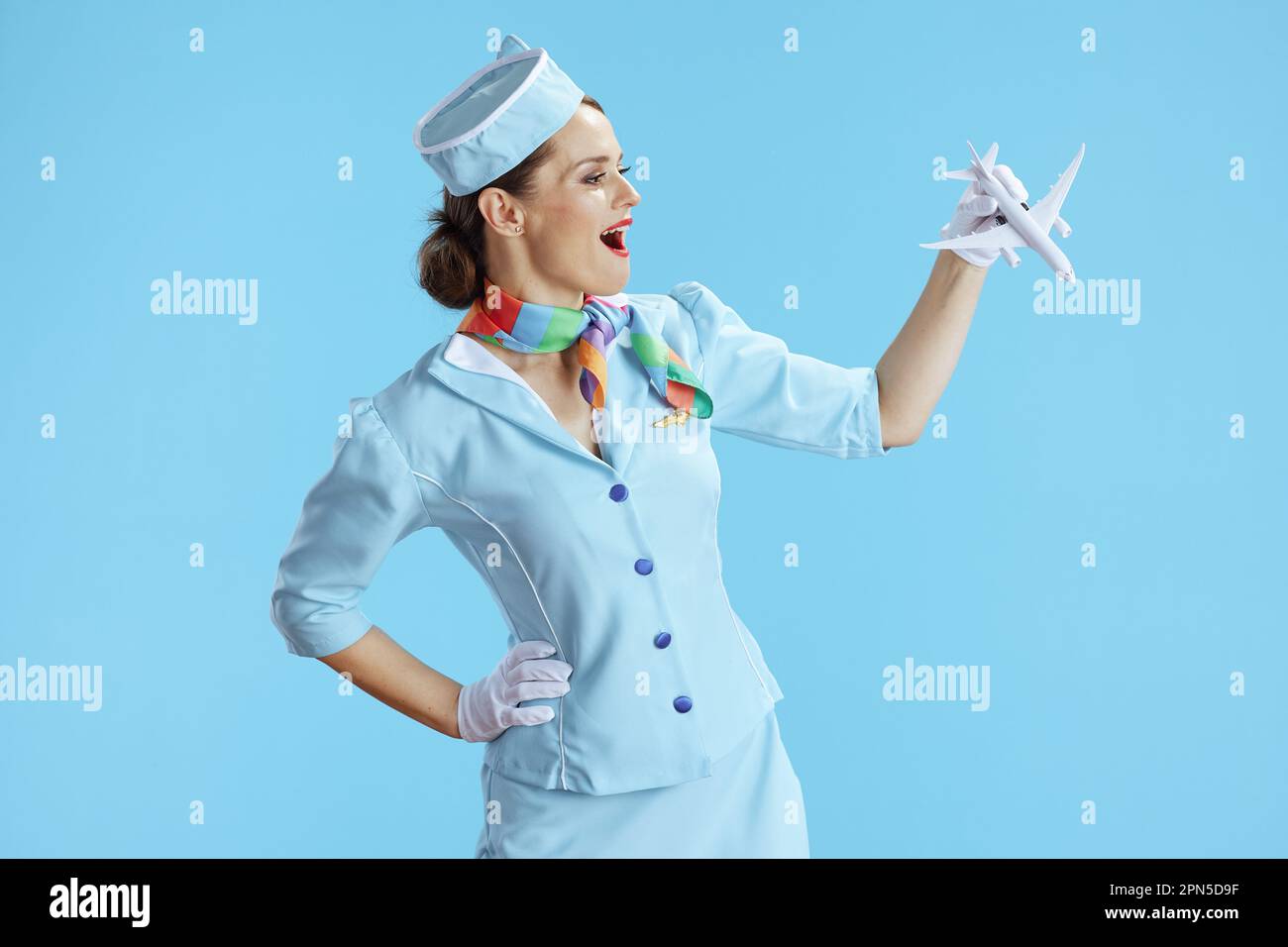 stylish air hostess woman against blue background in blue uniform with ...