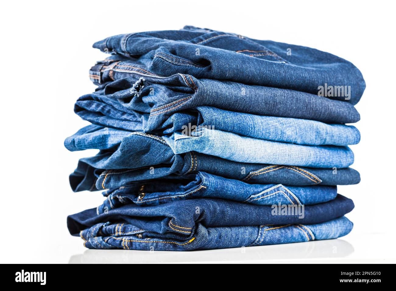 Stack of blue jeans on white Stock Photo - Alamy