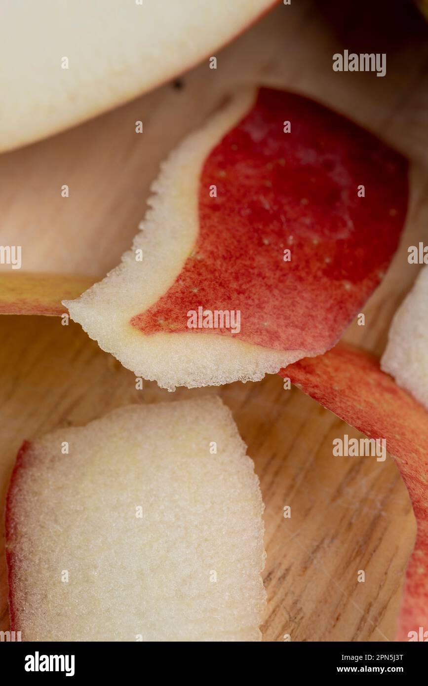 Peel and slice ripe red apples, delicious apples and their peel while ...