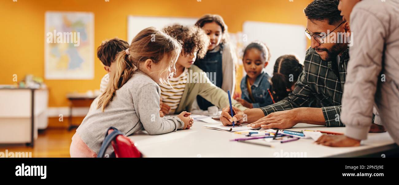 Art and creativity in an elementary school class. Teacher shows his ...