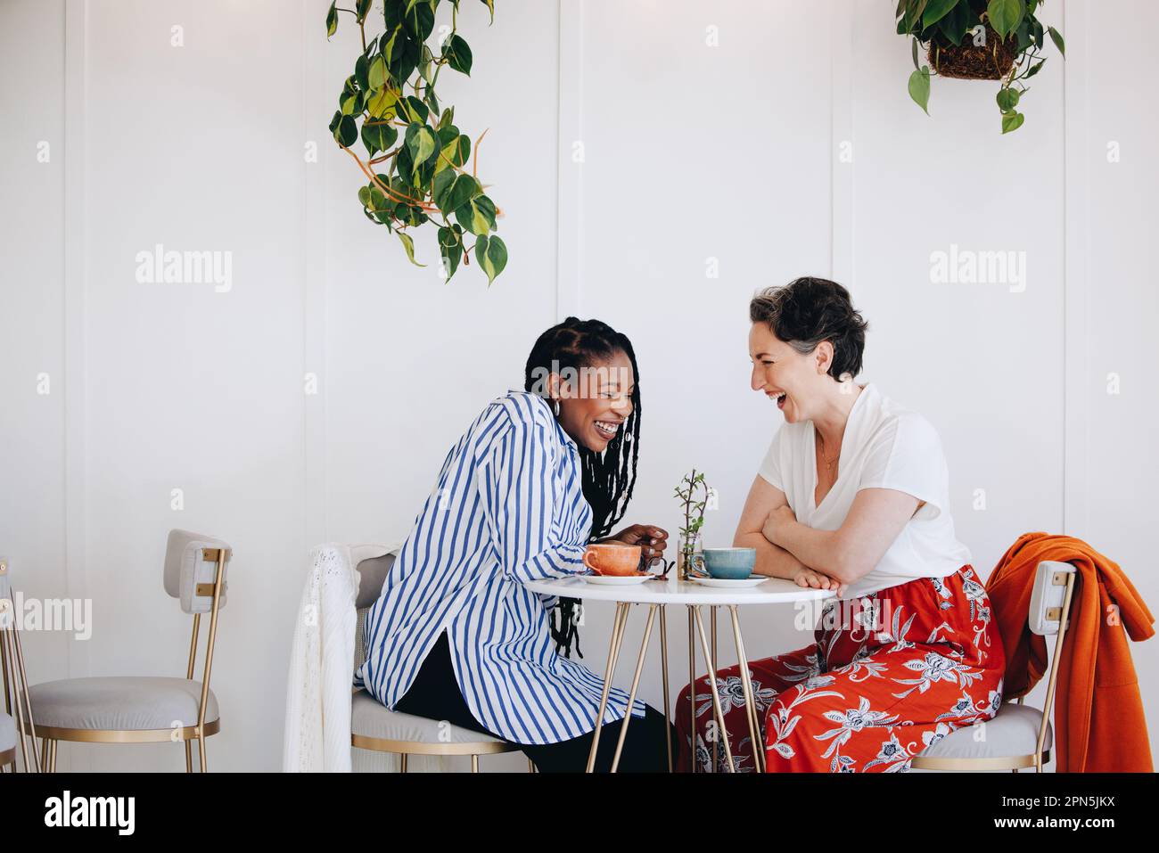 Happy Friends Laughing Together In Coffee Shop Two Female Friends