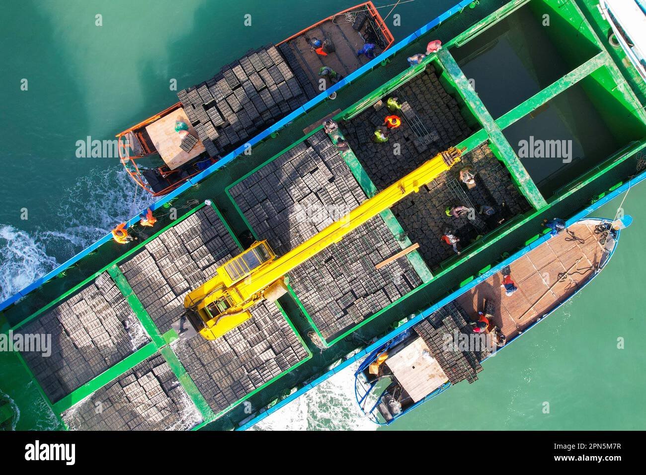 RONGCHENG, CHINA- APRIL 16, 2023 - Fishermen carry cages filled with ...