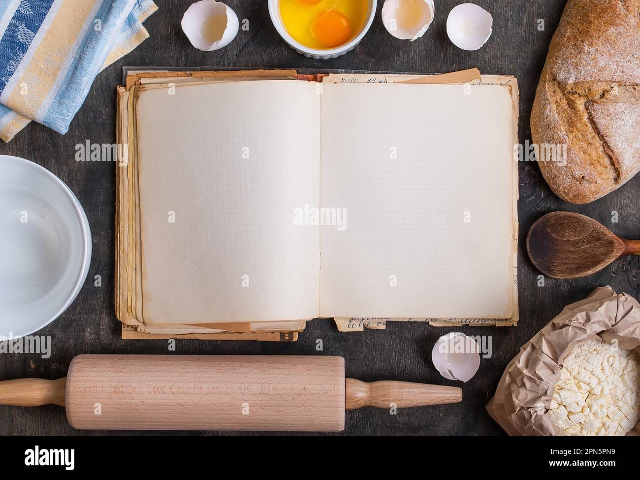 Baking dark background with blank cook book, eggshell, bread, flour ...
