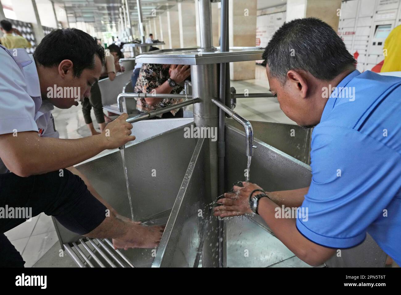 Muslim men wash before performing midday prayer at Istiqlal Mosque ...