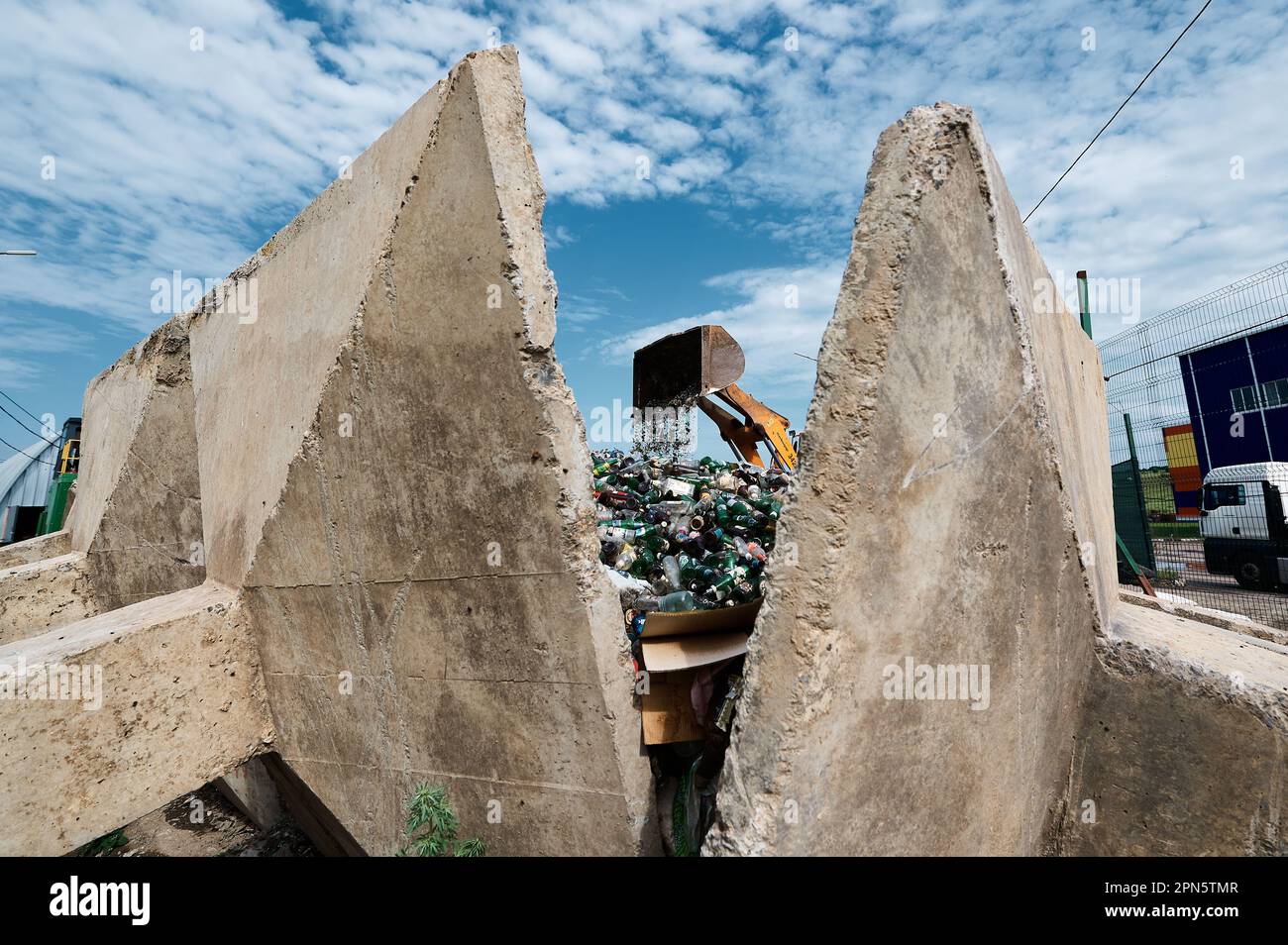 Pouring trash from excavator bucket on recycling plant yard Stock Photo ...