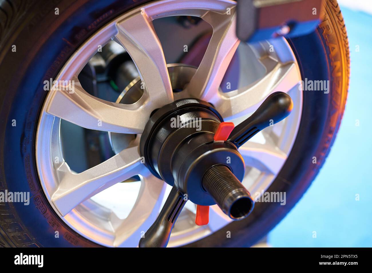 Car wheel with tire on balancing stand at repair shop Stock Photo - Alamy