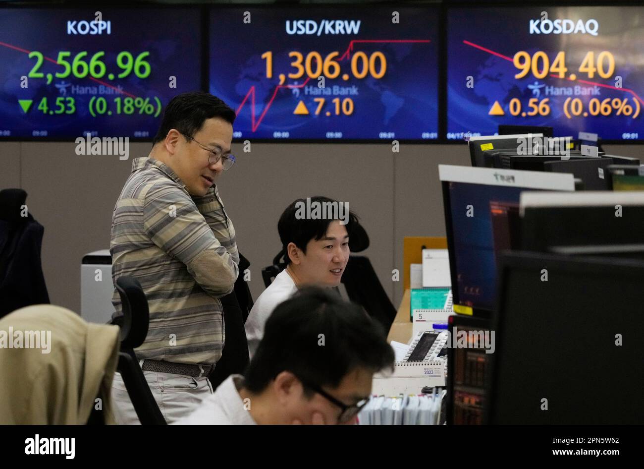 Currency traders watch monitors near the screens showing the Korea ...