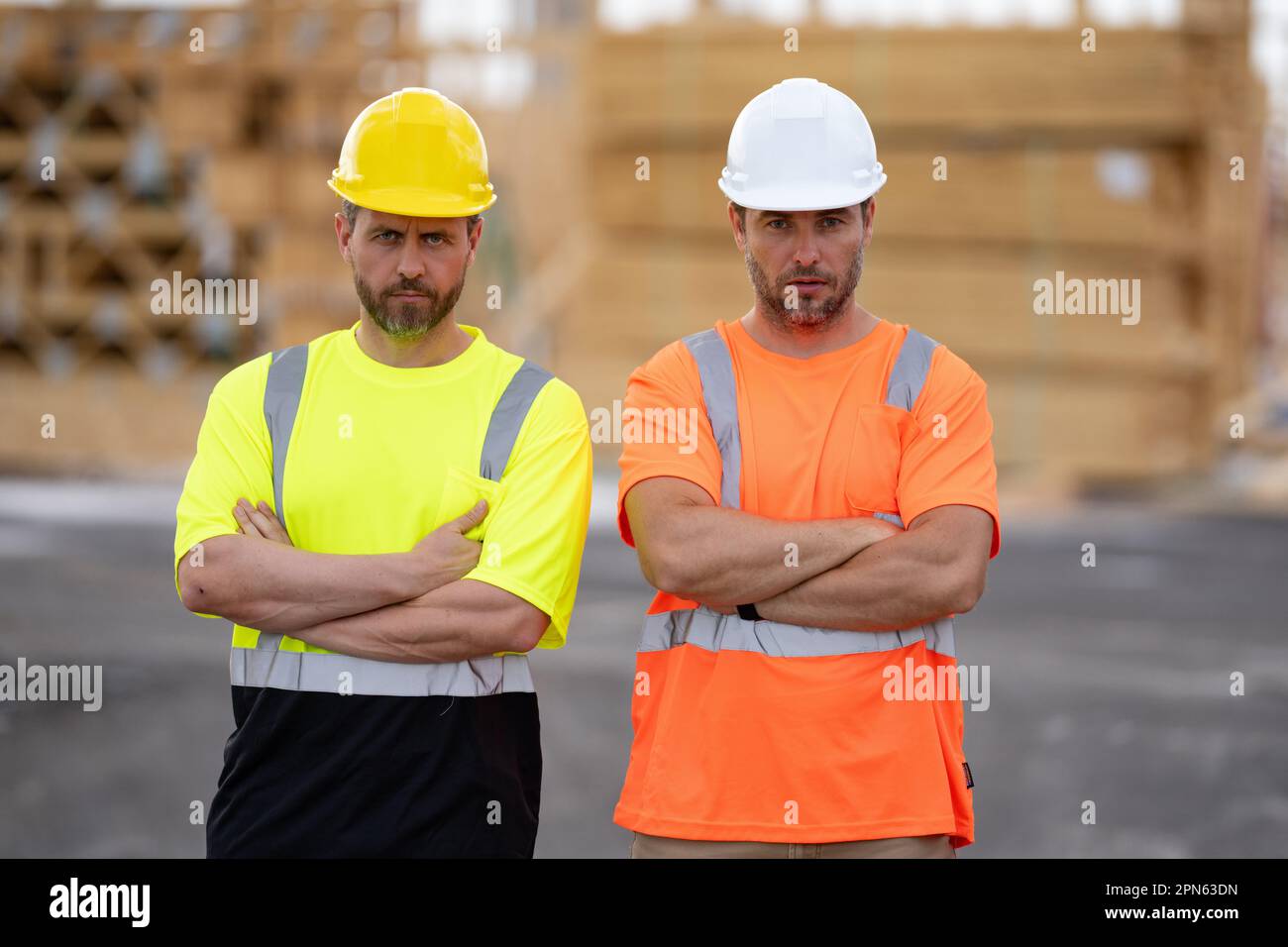 Construction workers at construction site. Serious men wearing safety ...
