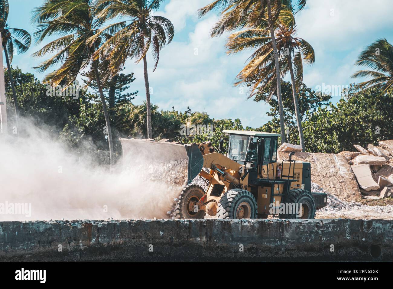Yellow mini bulldozer working with stone, moving soil and doing stone ...
