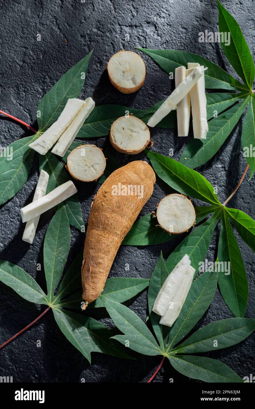pile of cassava fruit and cassava flour on a background of rustic and ...