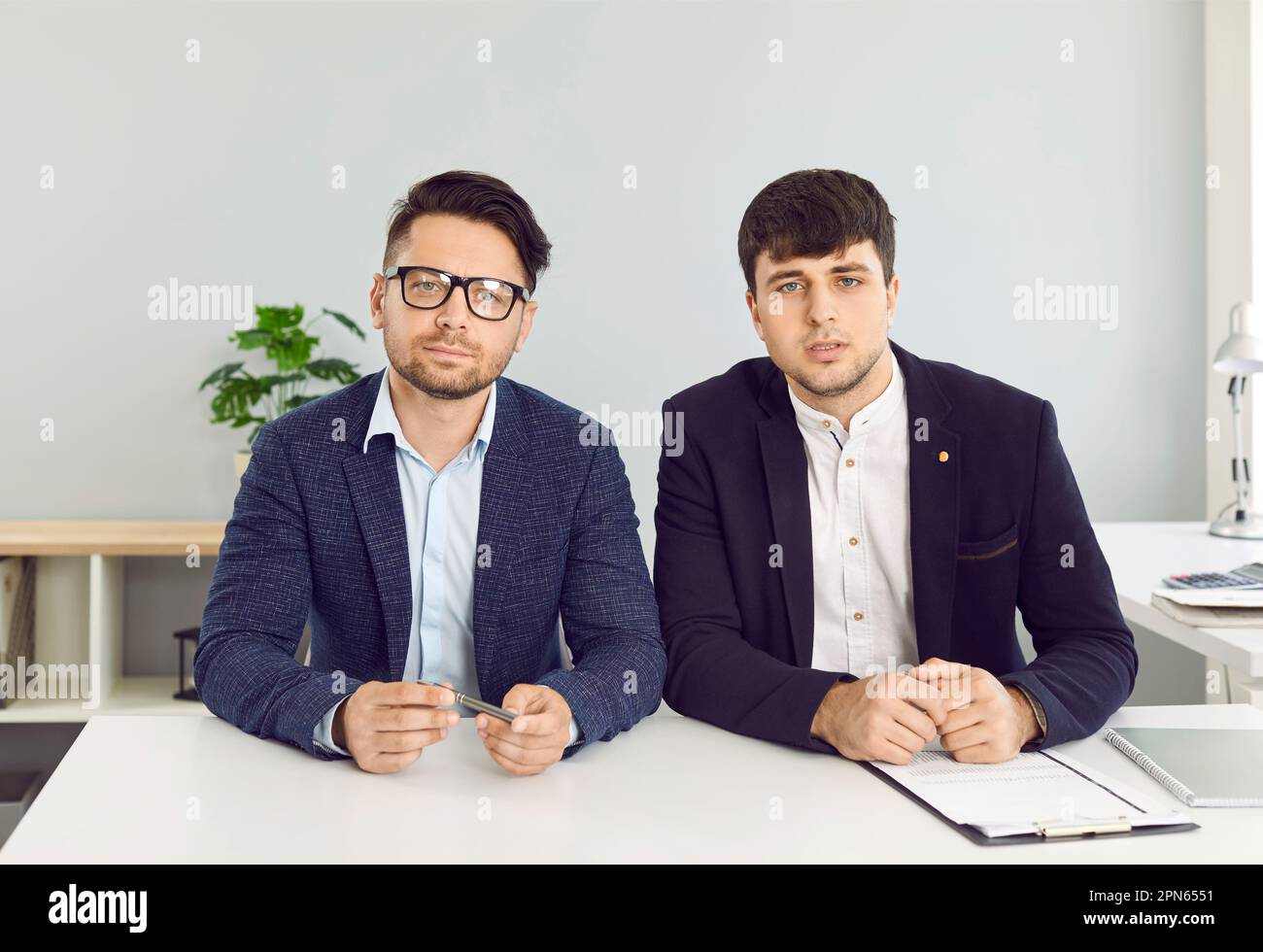 Webcam portrait of two business people sitting at office desk during ...