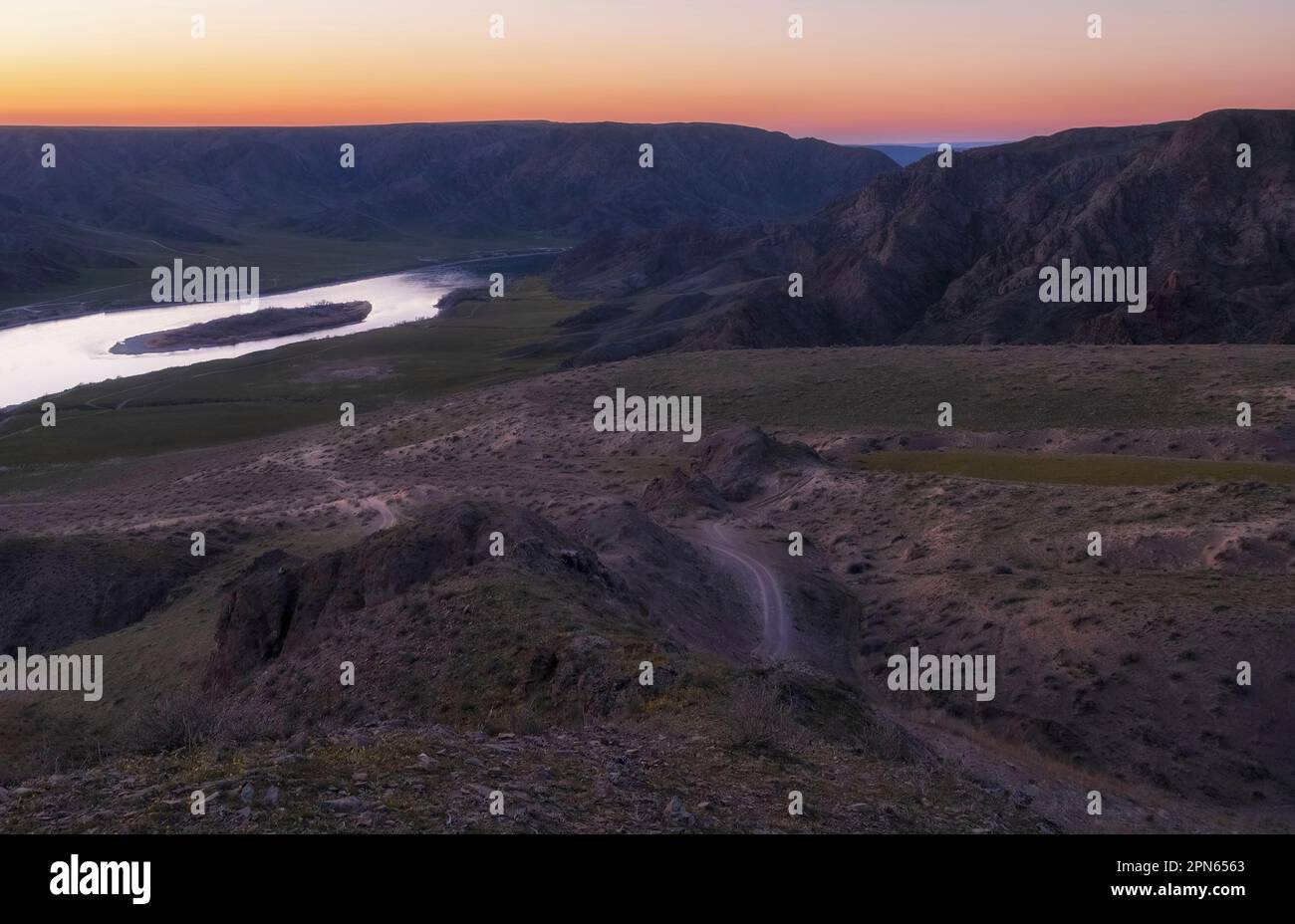 Dirt road to the river at sunset. Steppe landscape of Kazakhstan near ...