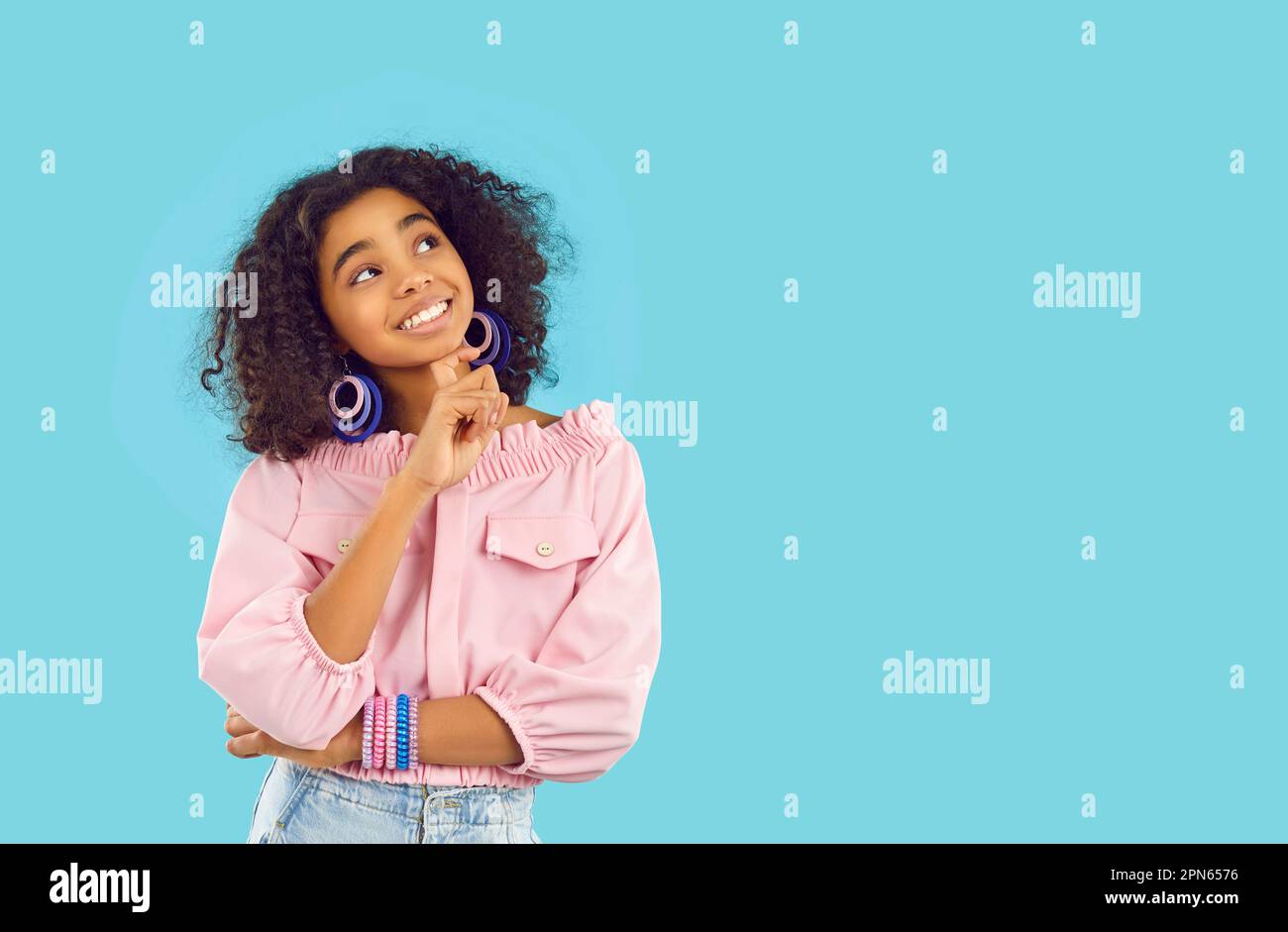 Happy child on blue copy space background thinking of something good ...