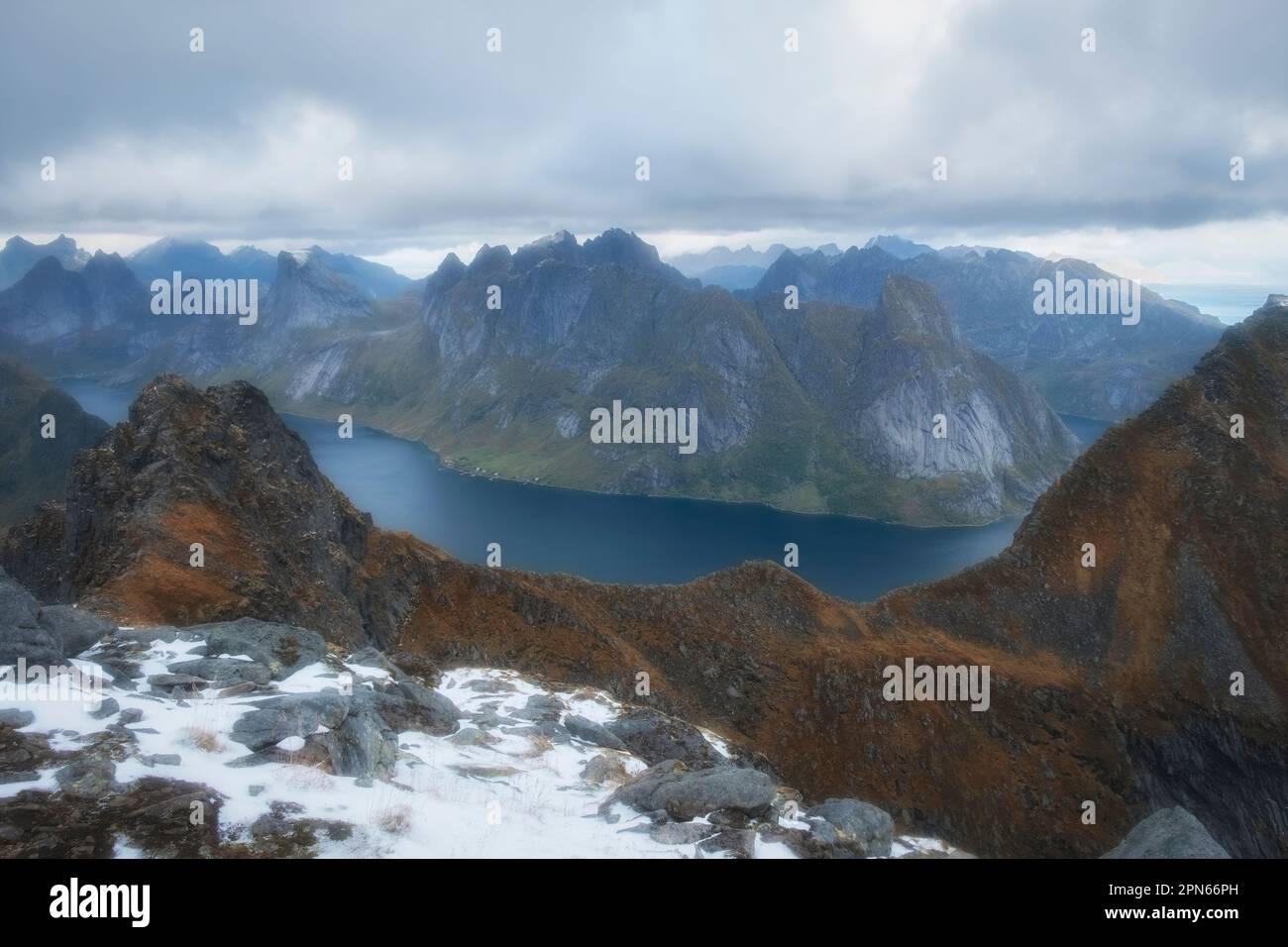 View from the top of Mount Munken to fjord under stormy sky at sunset ...